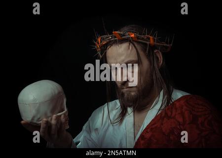 Jesus Christ with skull wearing a crown of thorns and white chiton toga ...