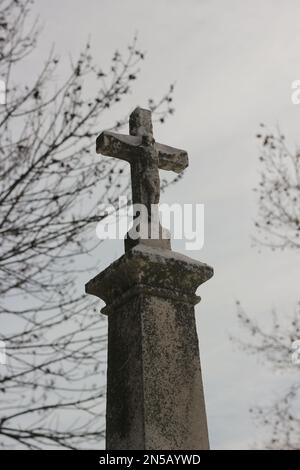 Simple vintage Christian cross standing high on a tombstone in the ...