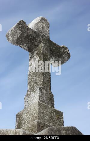 Simple vintage Christian cross standing high on a tombstone in the ...