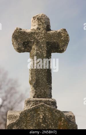 Simple vintage Christian cross standing high on a tombstone in the ...