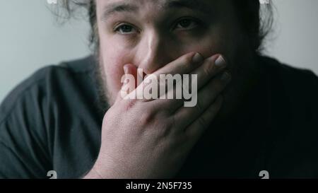 Preoccupied man suffering from mental pain. Close up face of a worried ...