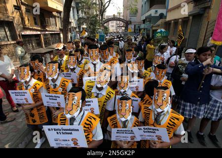 Indian school children wear tiger masks as they participate in an ...