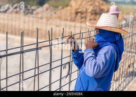 Worker bundle wire steel rod for construction job in building site ...