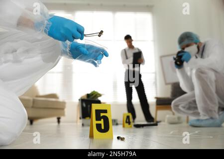 Investigators working at crime scene in messy room Stock Photo - Alamy