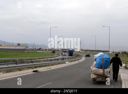 A man pulls an improvised cart filled with metal and plastics scavenged ...