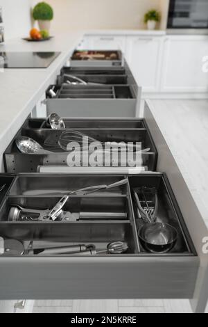 Open drawers with different utensils in kitchen Stock Photo - Alamy