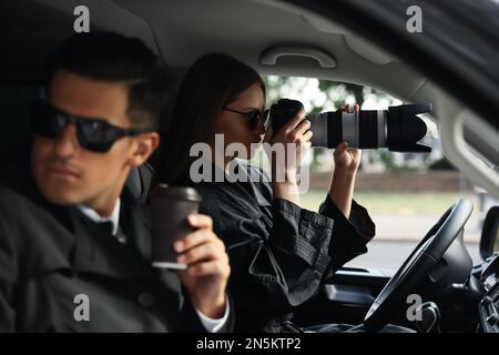 Private detectives with modern camera spying from car Stock Photo - Alamy