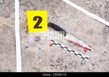 Crime scene investigation - Bloody knife and victims hand with yellow ...