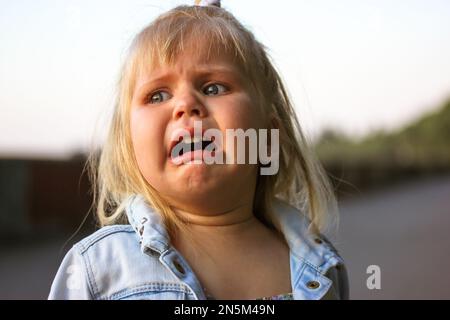 Unhappy child crying loudly with mouth open because of his parents ...