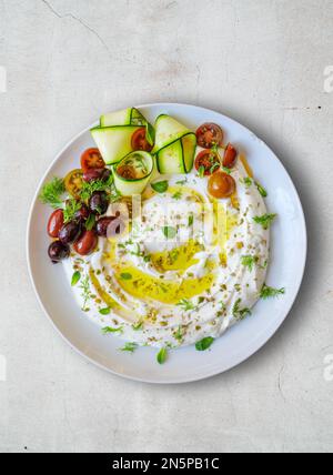 Labneh yogurt cream cheese with olive oil, zaatar, olives, vegetables ...