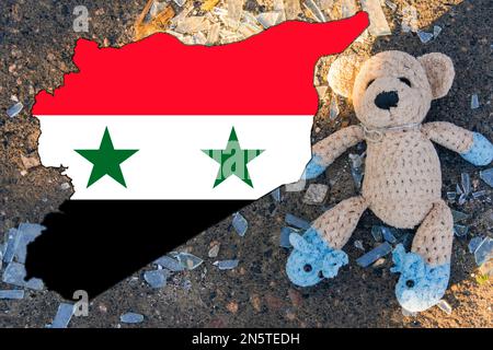 Teddy bear lies on fragments of glass and concrete. Picture in form of ...