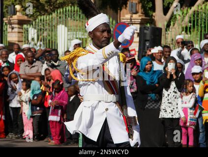 Hundreds of Sudanese watch a parade commemorating the 58th anniversary ...