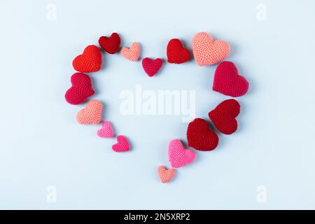 Multicolored crocheted hearts are laid out in the shape of the moon on ...