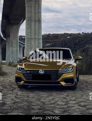 A vertical shot of a Volkswagen Arteon gold color Stock Photo - Alamy