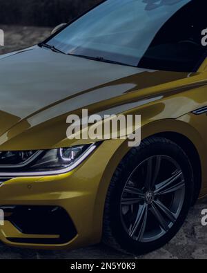 A vertical shot of a Volkswagen Arteon gold color Stock Photo - Alamy