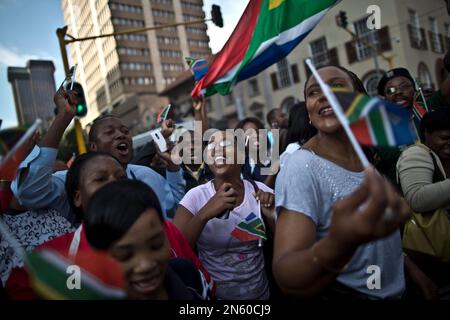 South African mourners, sing and chant slogans while waiting a hearse ...