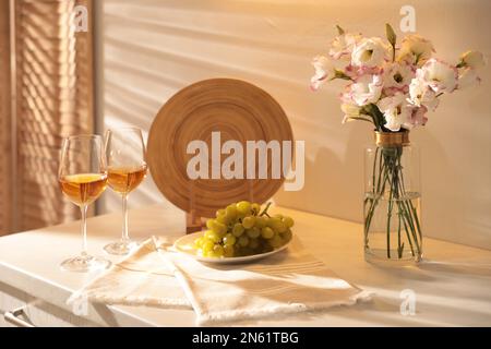 Bouquet of beautiful eustoma flowers and grapes on white table in ...