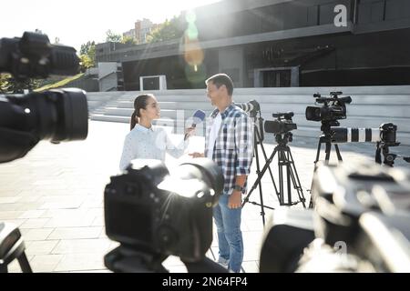 Young journalist interviewing man on city street Stock Photo - Alamy