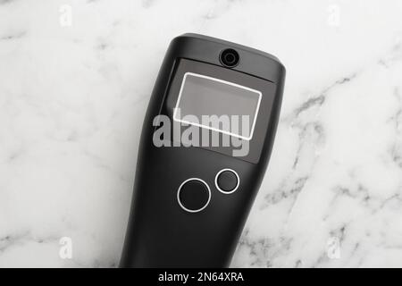 Modern breathalyzer with blank screen on light grey stone table, top ...