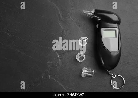 Modern breathalyzer and mouthpieces on black background, flat lay Stock ...