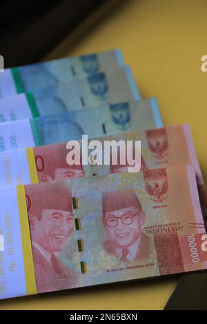 stacks of IDR 100,000 and IDR 50,000 rupiah banknotes on black ...