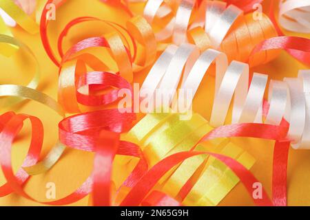Colorful serpentine streamers on yellow background, closeup Stock Photo ...