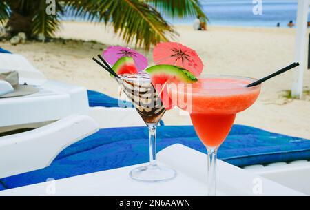 Tropical cocktails table by sun-lounger on beach at Rarotonga Cook ...