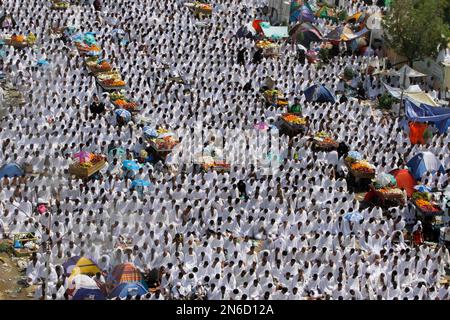 Muslim pilgrims pray the noon prayers outside Namira Mosque in Arafat ...