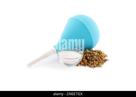 Blue enema, soda powder and dry chamomile flowers on white background ...