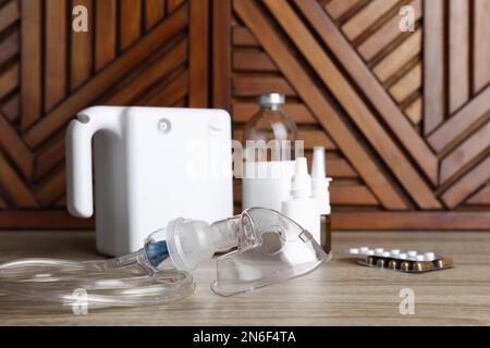 Modern nebulizer with face mask and medications on white background ...