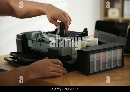 Repairman with screwdriver fixing modern printer in office Stock Photo ...