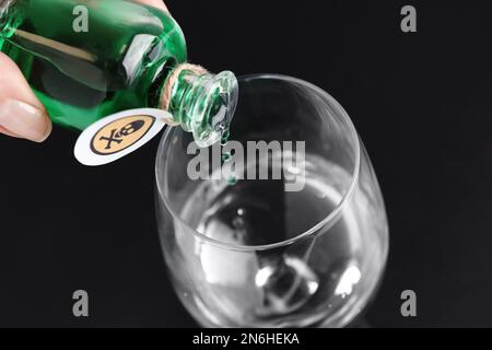 Woman pouring poison into glass of water on white background, closeup ...