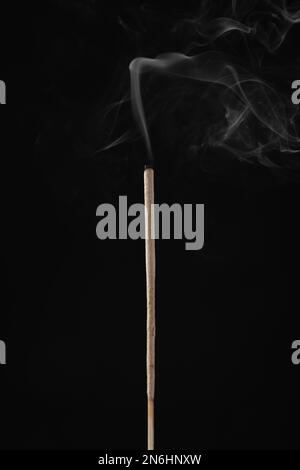 Incense stick smoldering on black background, closeup Stock Photo - Alamy