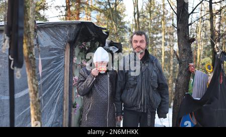 A homeless man and woman giving an interview in the winter in the woods ...
