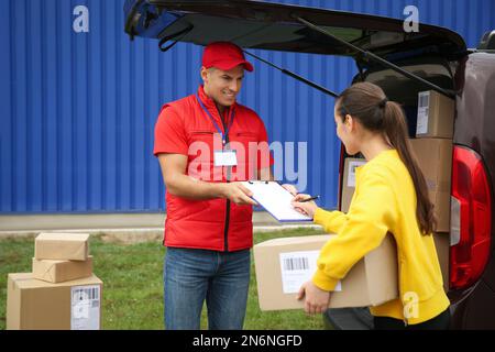 Courier receiving receipt signature from customer outdoors Stock Photo ...