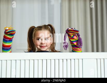 Cute little girl performing puppet show at home Stock Photo - Alamy