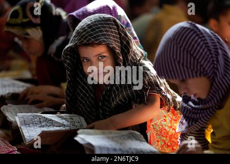 Pakistani students of a madrassa, or Islamic school, recite verses of ...