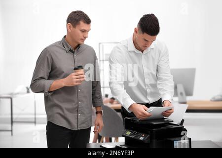 Employees using new modern printer in office Stock Photo - Alamy