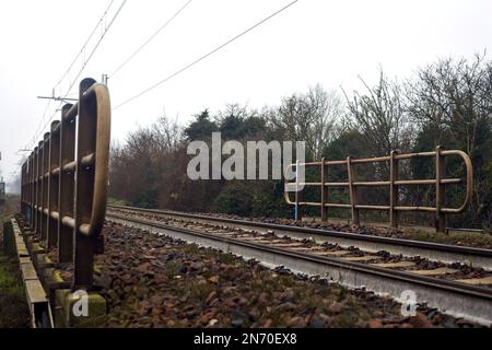 Railroad on an embankment bordered by trees on a misty day in winter ...