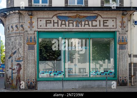 Urban pharmacy entrance with glass facade and glowing medical cross ...