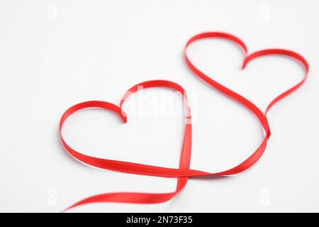 Hearts made of red satin ribbon on beige background. Valentine's Day ...