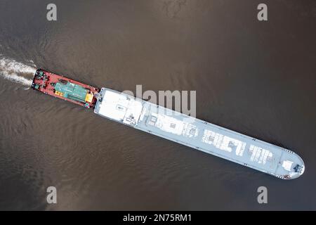 Pusher vessel "TR 15" pushes hull of newly built tanker up the river ...