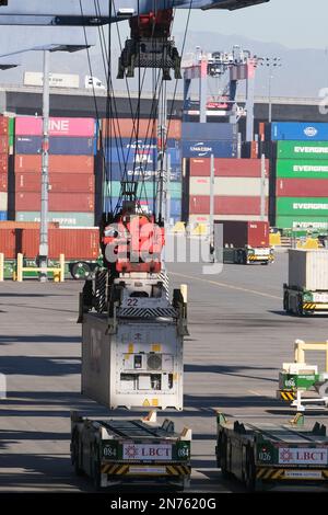 Computer-controlled cargo cranes rapidly lift containers from ships to ...