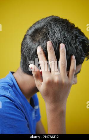 teenage boy Scratching Head Against black background Stock Photo - Alamy