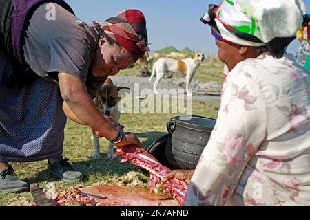 Family members of Xhosa tribe member Baba Mfundisi grill goat meat ...