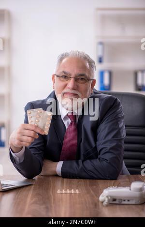 Old male employee feeling bad at workplace Stock Photo - Alamy