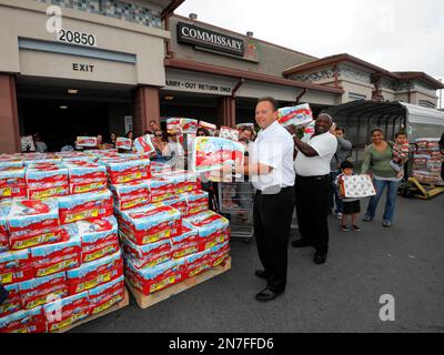 Scott Hill, Camp Pendleton Commissary Director, center, distributes a ...