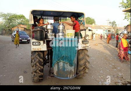 Villagers transport drinking water in plastic containers on their ...