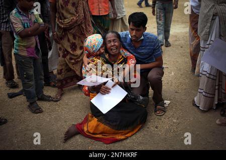 A woman is comforted as she grieves after identifying the body of her ...