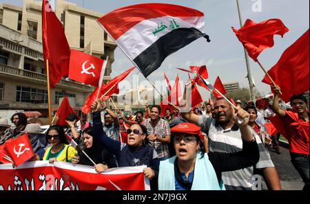 Supporters of the Iraqi Communist Party wave hold symbolic sickles ...